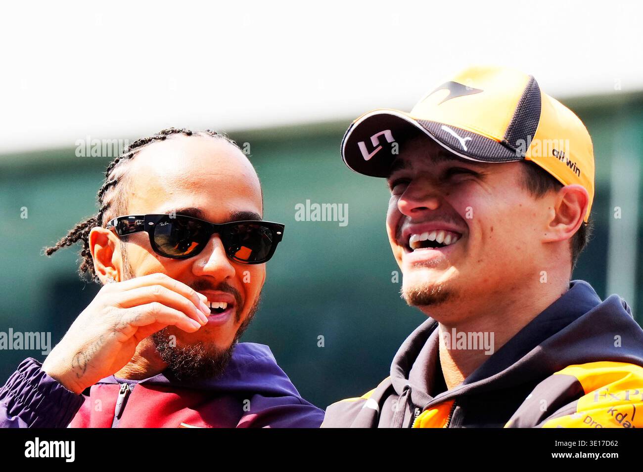 Lewis Hamilton of Scuderia Ferrari HP runs and Lando Norris of McLaren ...