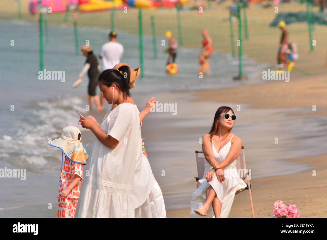 Tourists enjoy beach activities during spring season in Sanya Bay ...