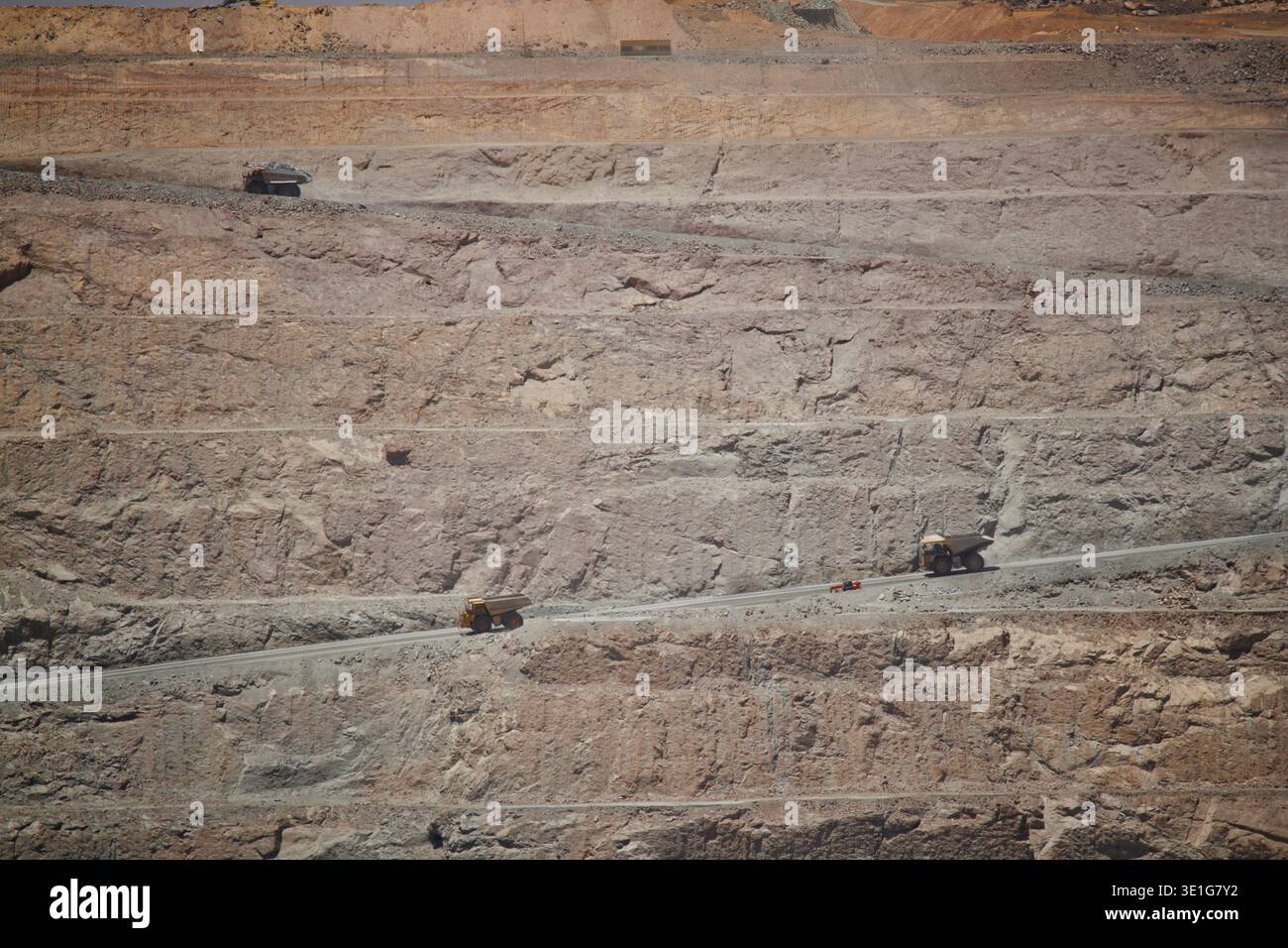 Mine haul trucks carry gold, rock, and tailings up from the bottom of ...