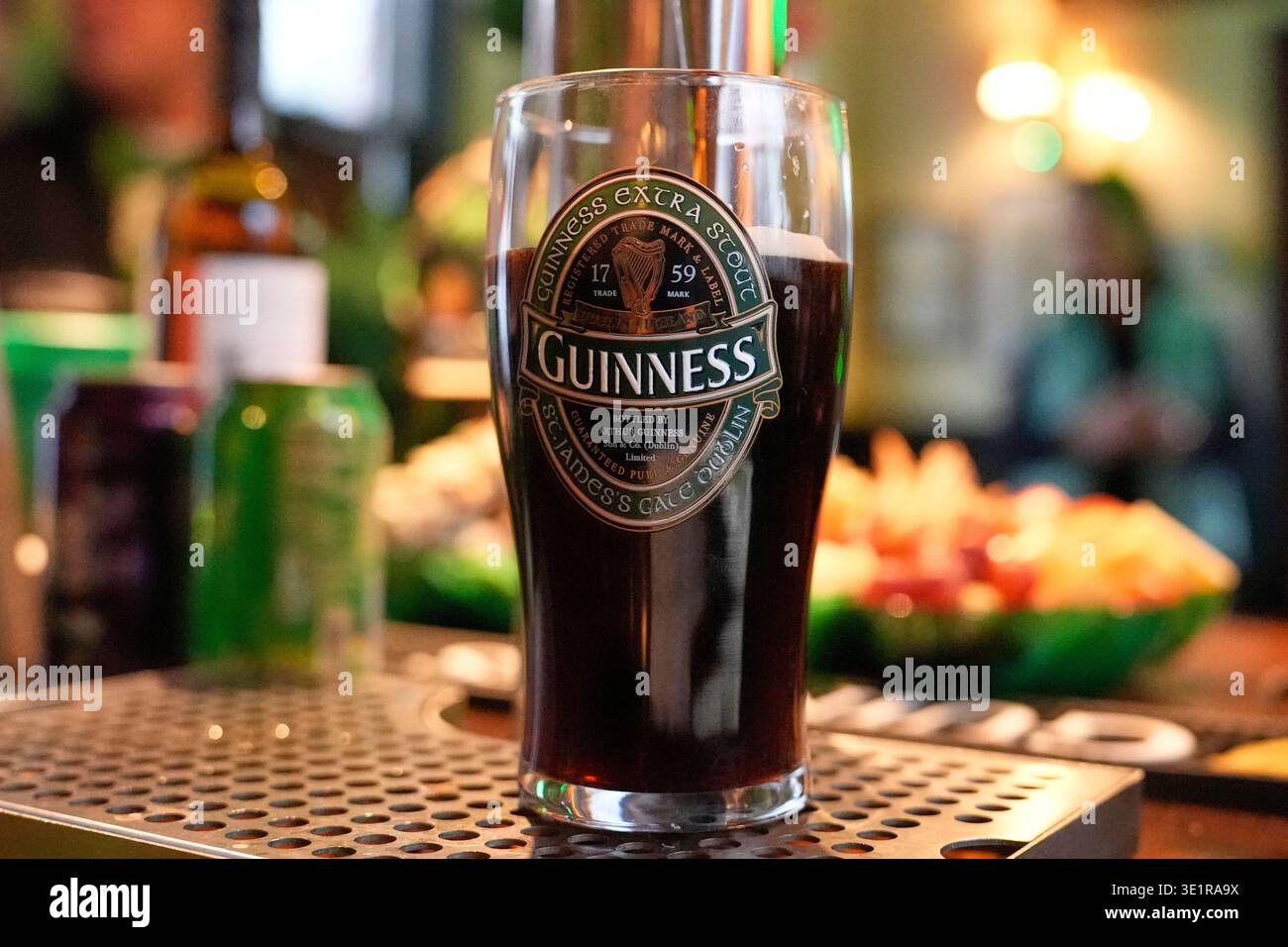A pint of Guinness is poured at an early St. Patrick's Day party in a ...