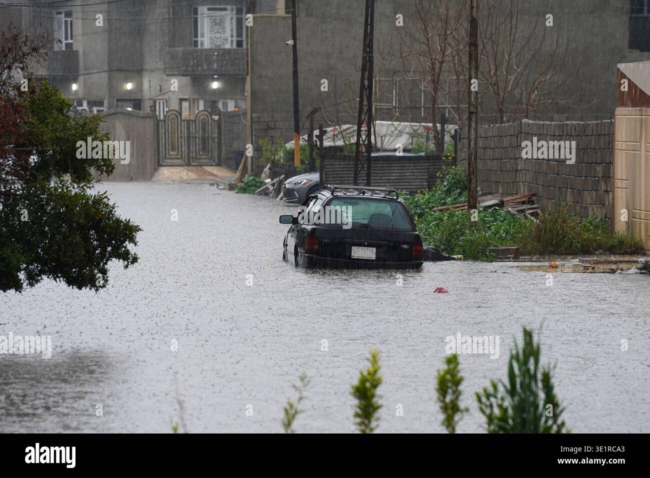 A car parked in a flooded street in Mosul after heavy rains caused ...
