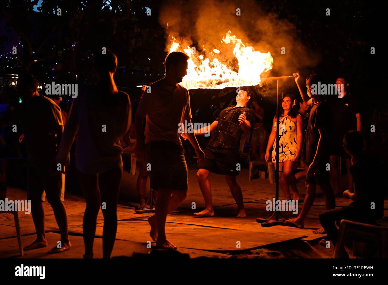 Tourists enjoying a fire limbo activity on Loh Dalum Beach, Phi Phi ...