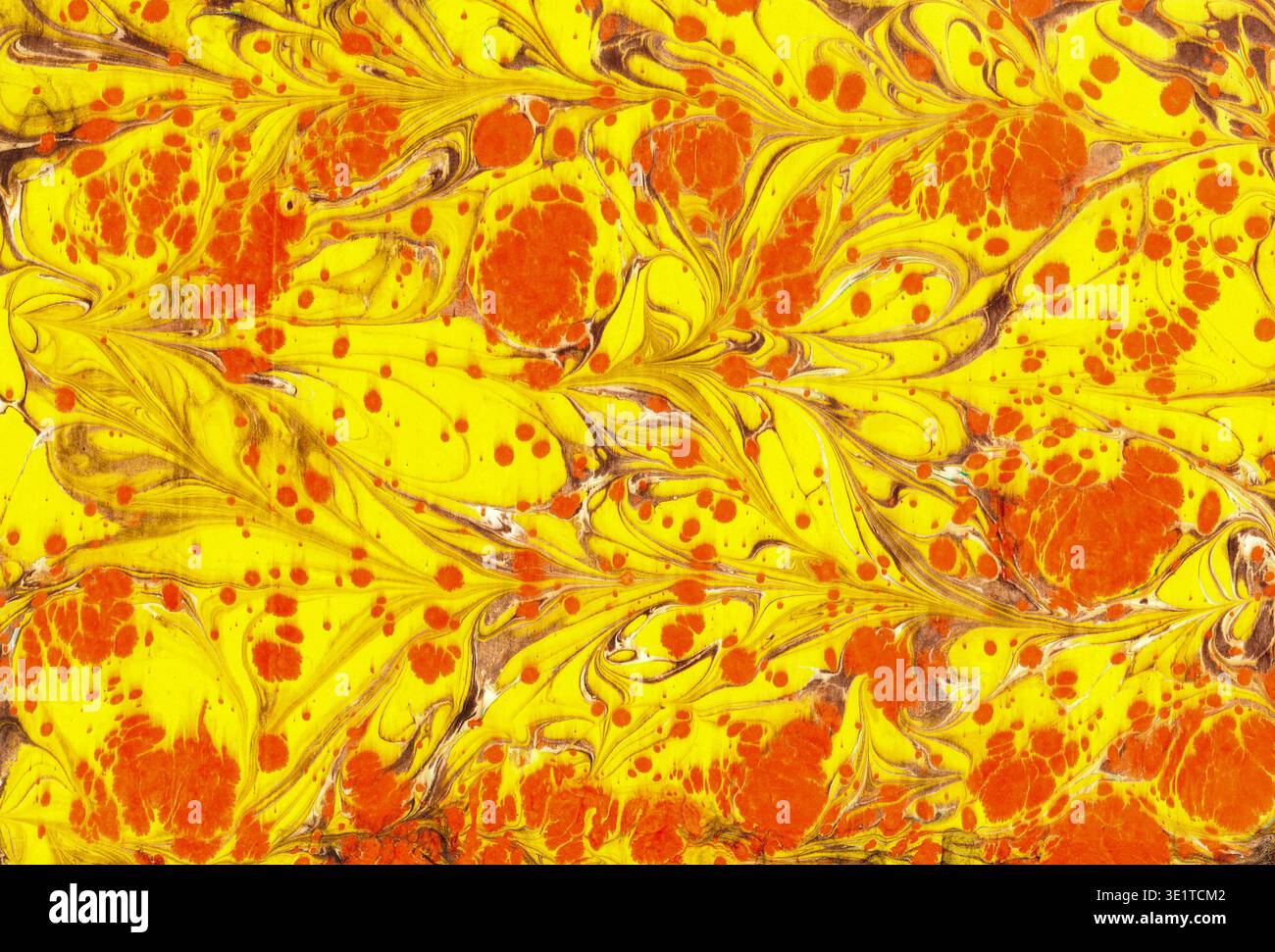 Vibrant yellow and orange Turkish marbled paper texture with feathered ...