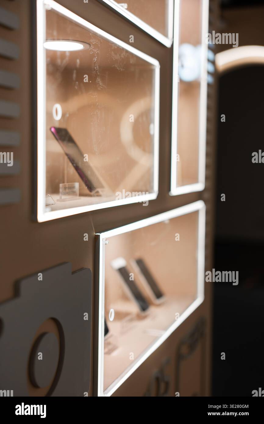 Modern smartphone display in illuminated retail kiosk at urban ...