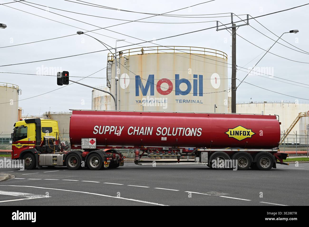 A truck transporting petroleum fuel passes by signage at the ExxonMobil ...