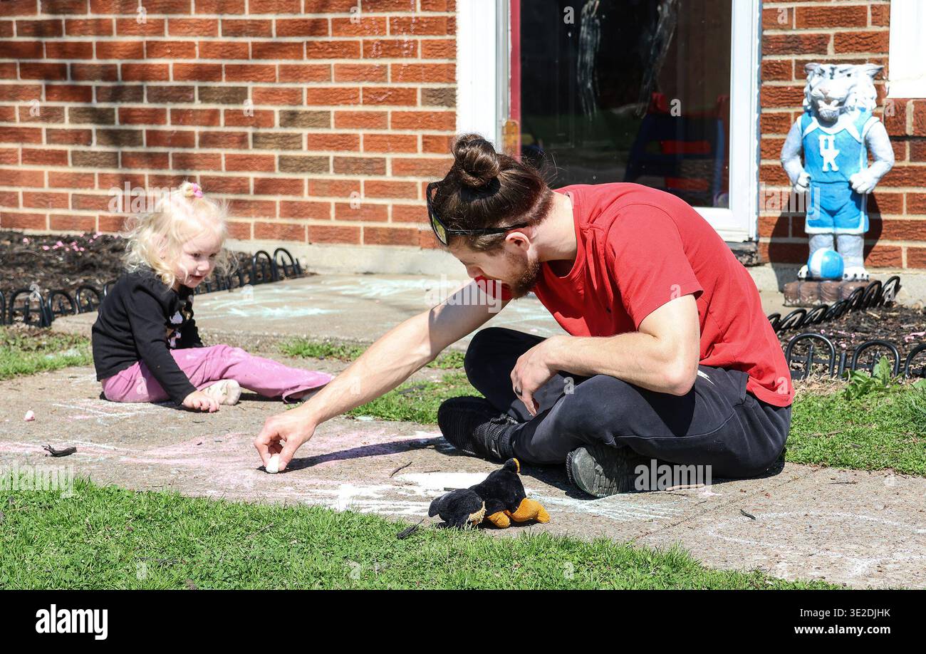 Charlotte DeLacey, left, watches her dad, Tyler DeLacey, as they draw ...