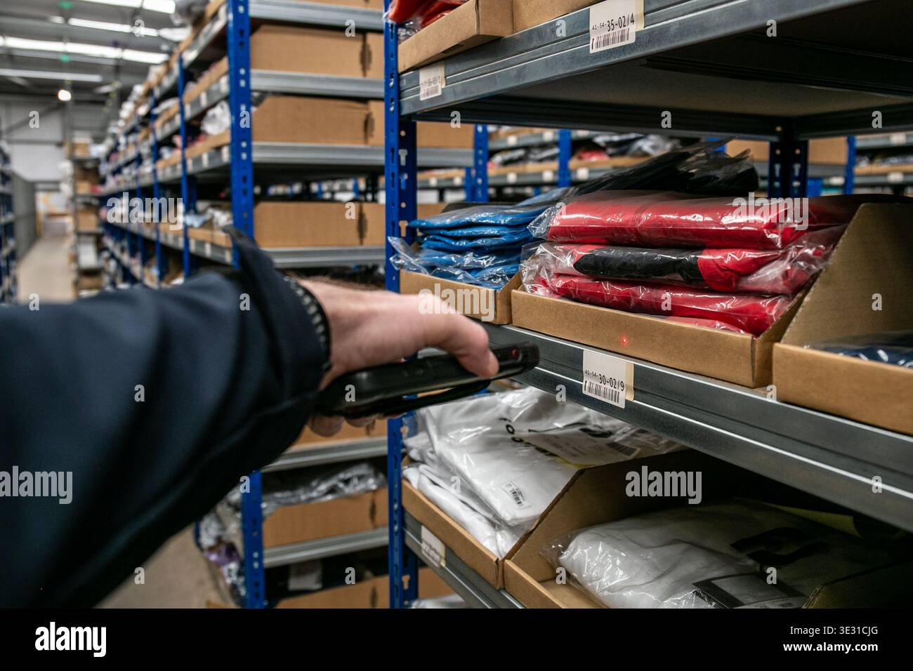 Warehouse operative using a handheld barcode scanner to scan a location ...