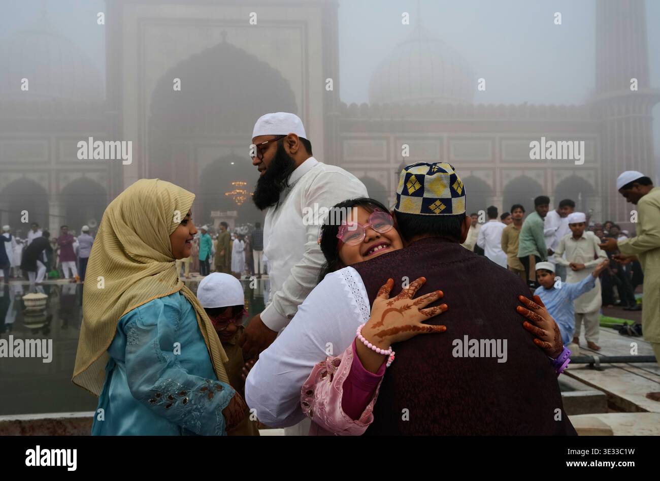 A girl hugs her father after offering Eid al-Fitr prayers to mark the ...