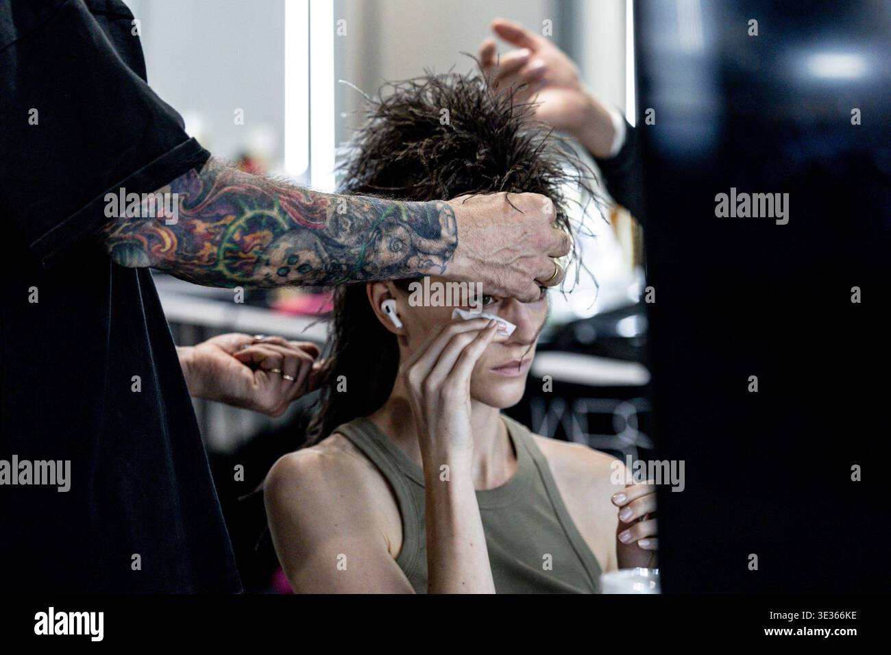 A hairdresser styles a model backstage during Madrid Fashion Week 2026 ...