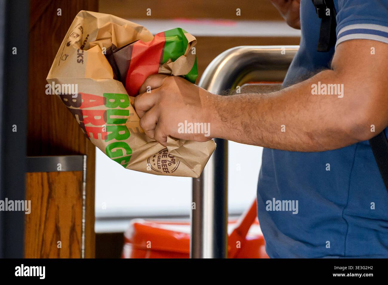 A customer holds packaging from a Hungry Jacks’ fast food outlet in ...