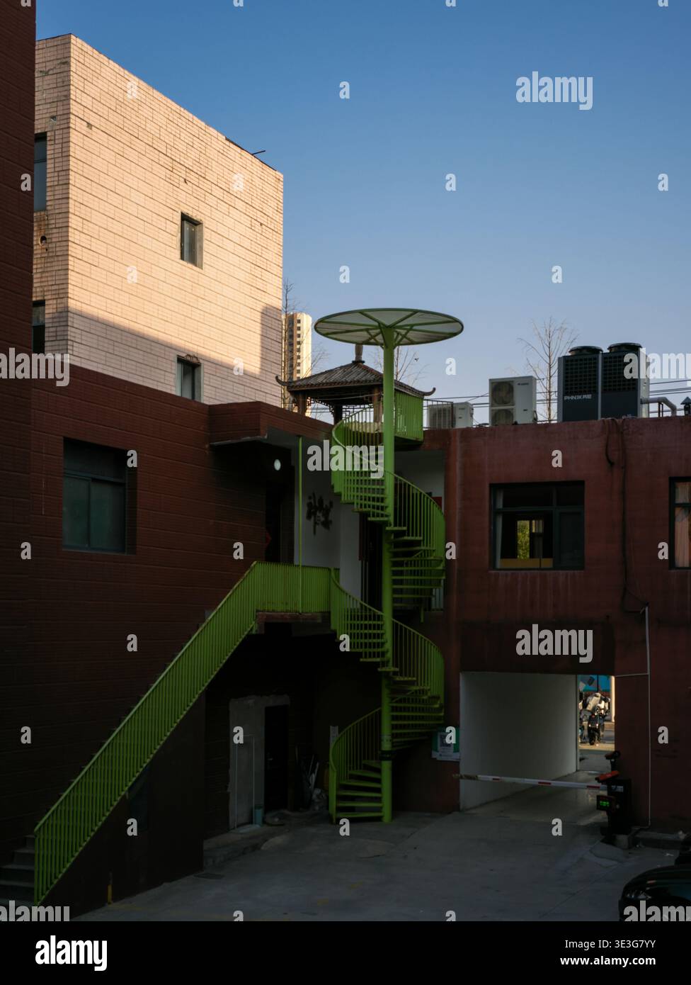 Wuhan, China - March 22, 2025: A green metal spiral staircase attached ...