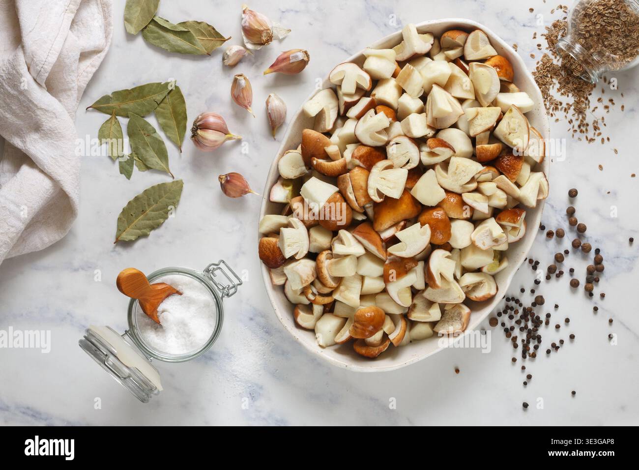 Sliced raw fresh porcini mushrooms in a white plate on a marble ...