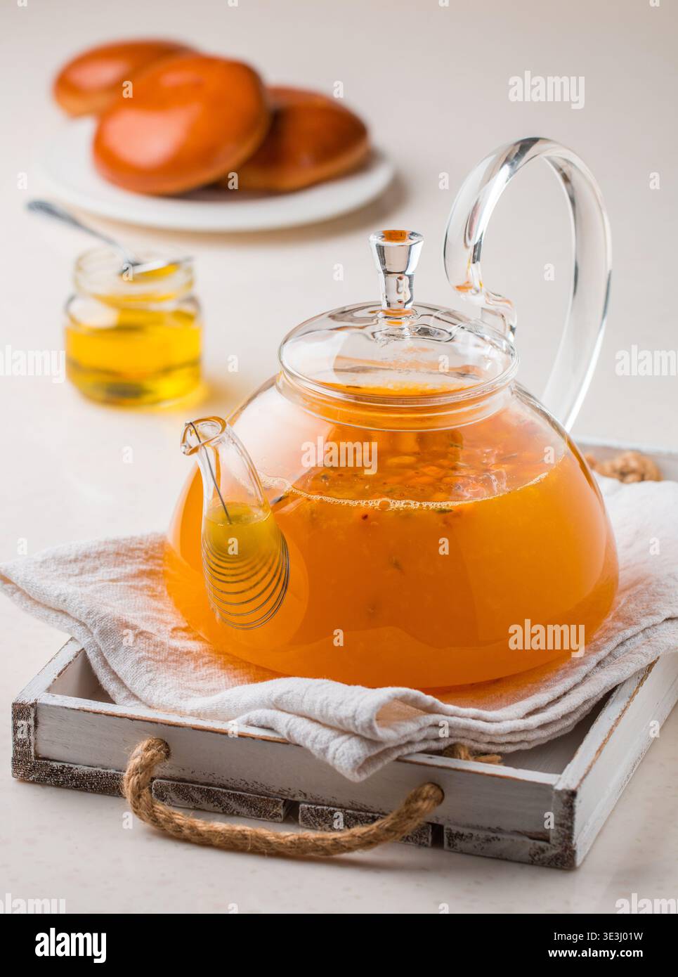 Vitamin hot sea buckthorn tea in a small glass teapot with fresh raw ...
