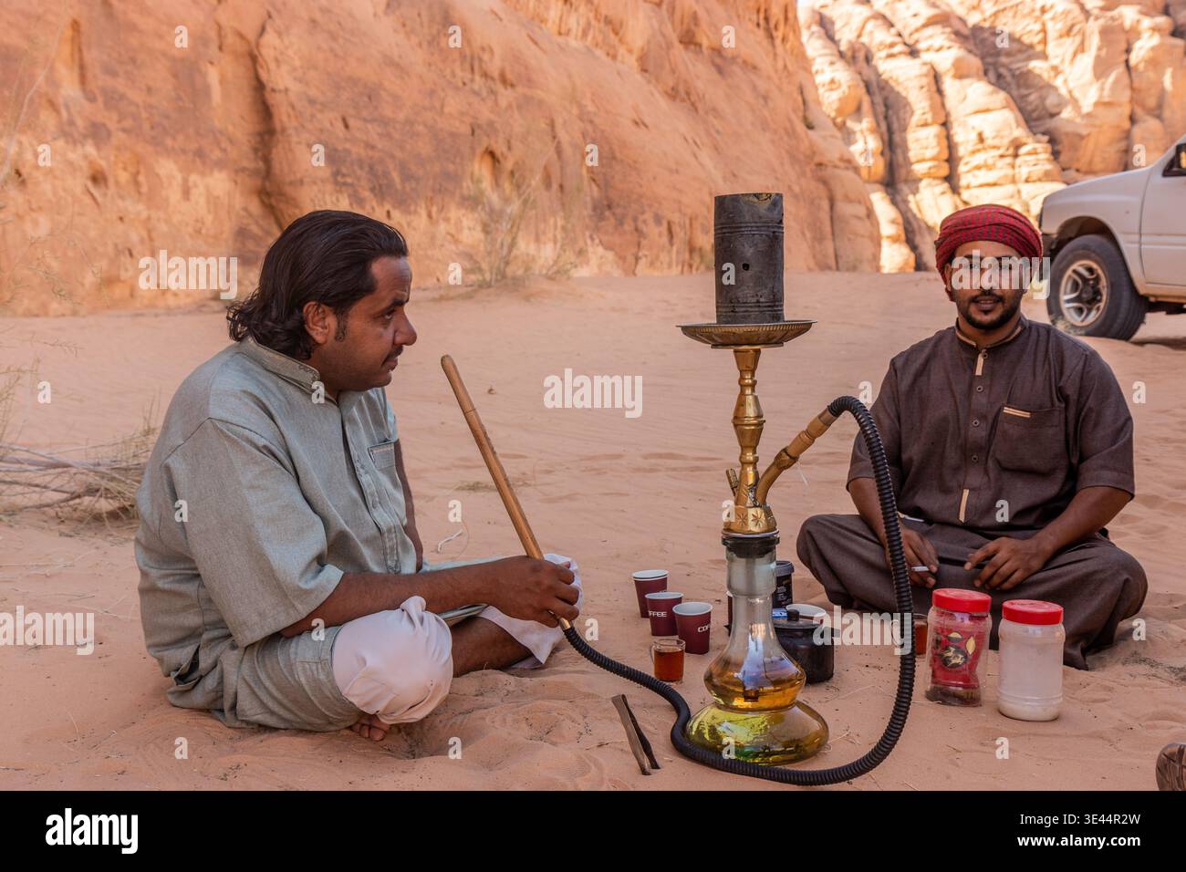 WADI RUM, JORDAN - JULY 13, 2022: Two bedouin men smoking a hookah ...
