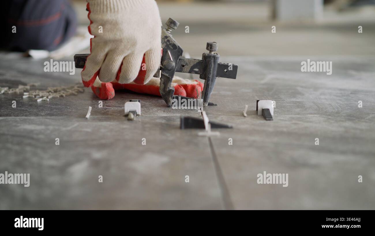 Fastening ceramic tiles during installation, close-up. Laying floor ...
