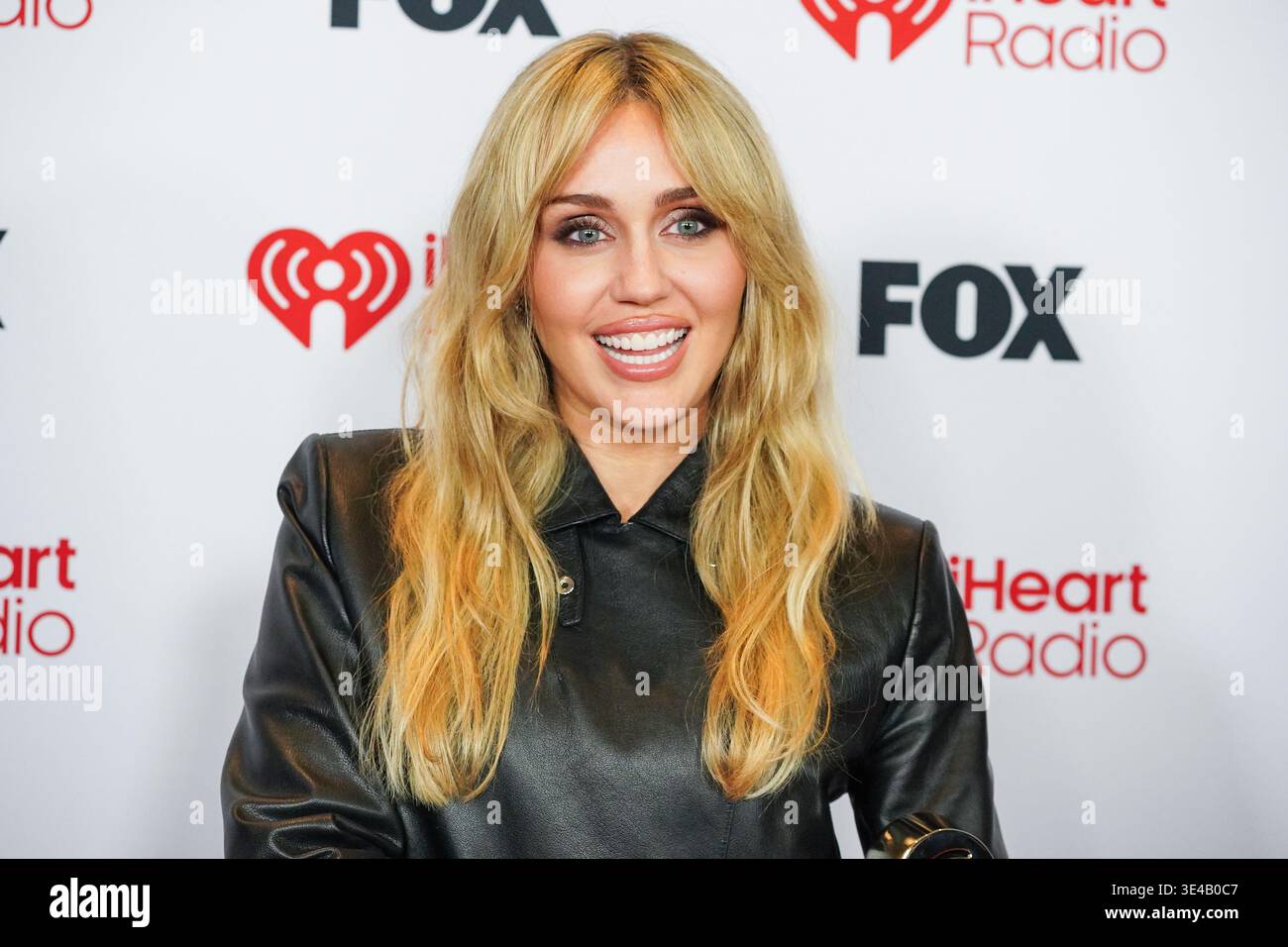 Miley Cyrus poses in the press room during the IHeartRadio Music Awards ...