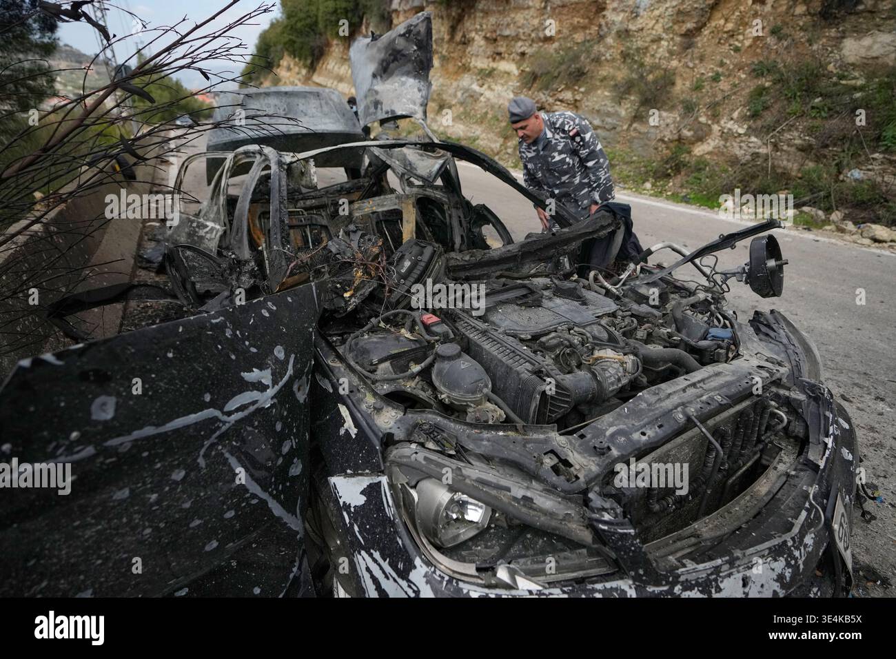 A policeman checks the charred car that was carrying Hezbollah's al ...
