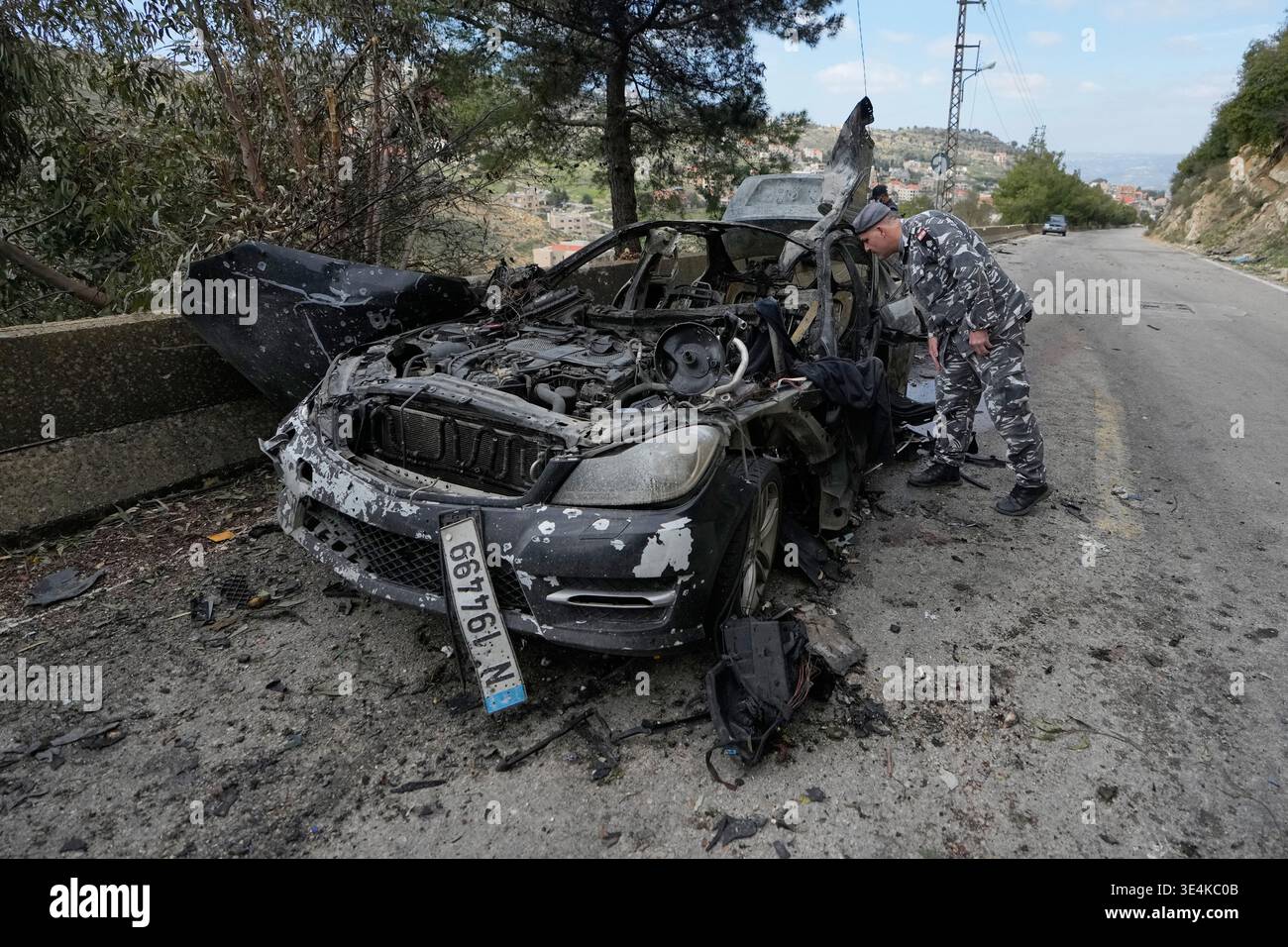 A policeman checks the charred car that was carrying Hezbollah's al ...