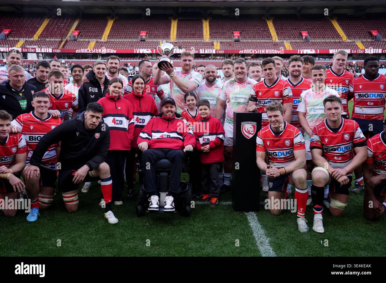 Leicester Tigers' Ollie Chessum lifts the trophy as players from both ...
