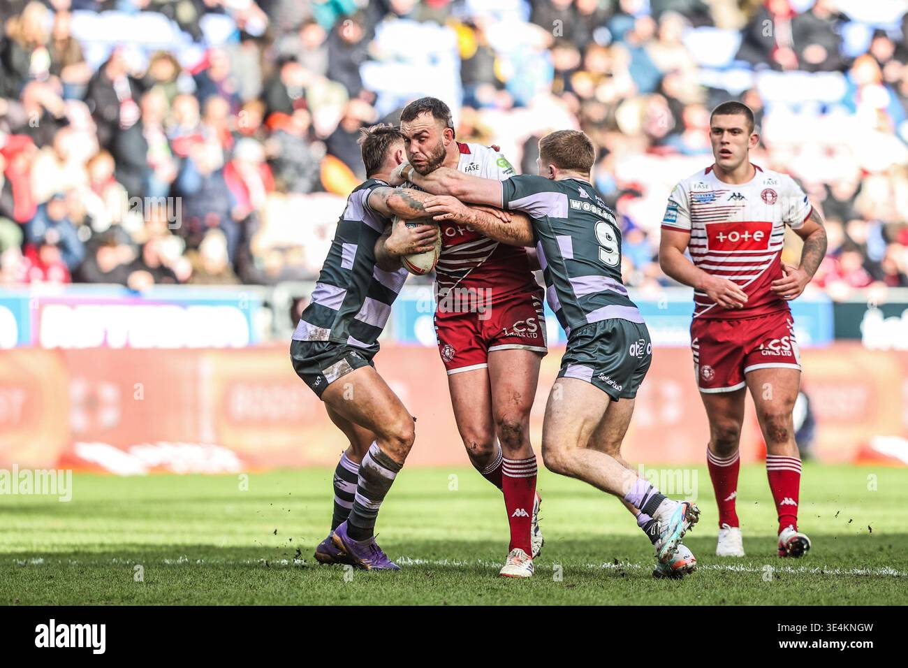 Kaide Ellis of Wigan Warriors is tackled by Zac Woolford of ...