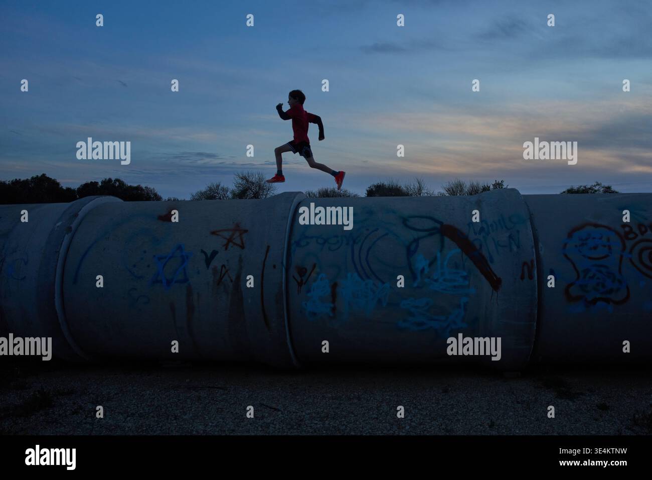 A boy plays outside a cement pipe turned into a bomb shelter as a ...