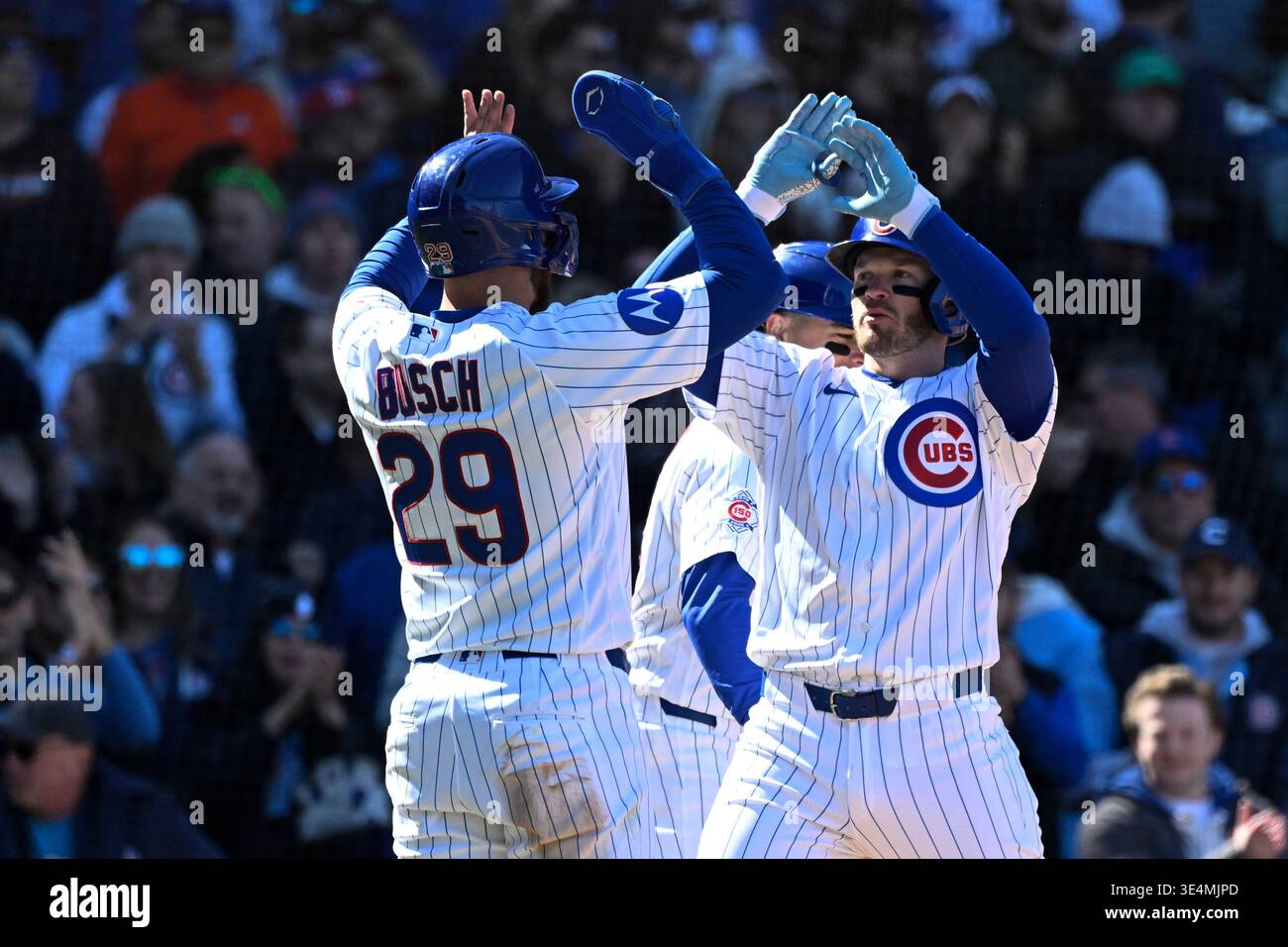 Chicago Cubs' Ian Happ, right, high-fives Michael Busch (29) after they ...