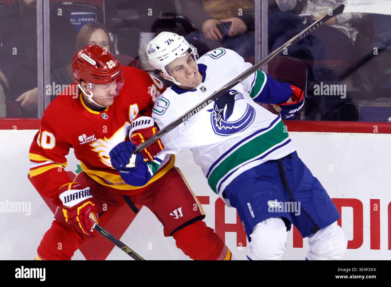 Vancouver Canucks' Zeev Buium (24) battles with Calgary Flames' Blake ...