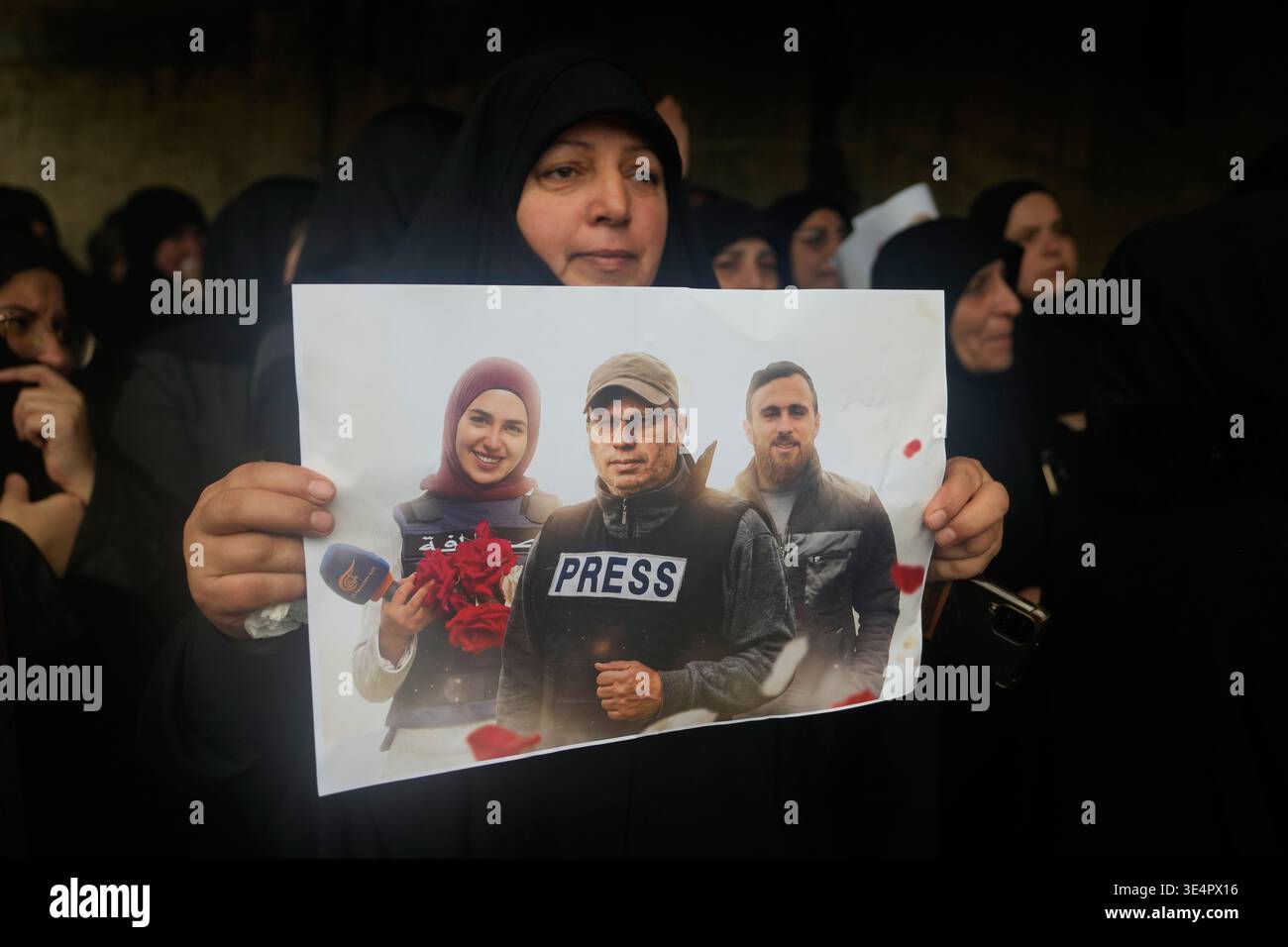 A woman holds a poster showing Hezbollah's Al-Manar TV correspondent ...