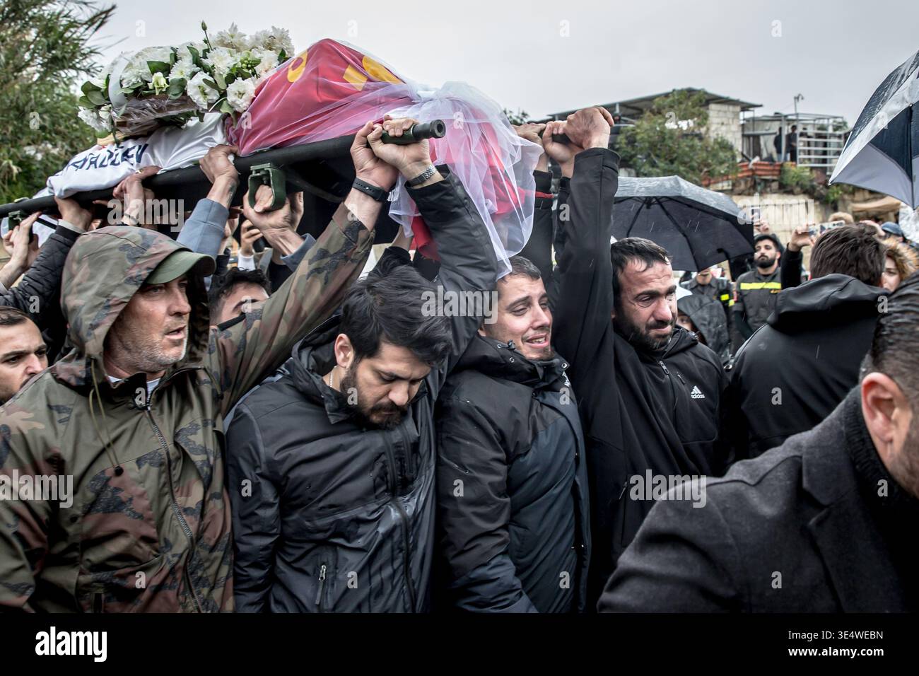 A coffin is carried through a cemetery in Choueifat, south of Beirut ...