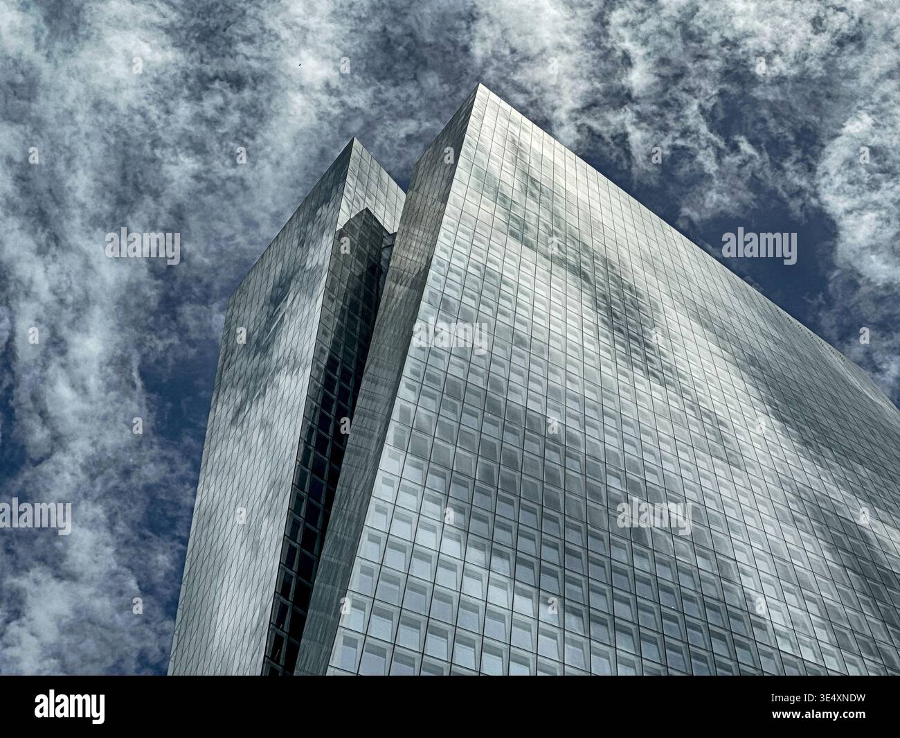 Glass windows reflect the clouds in the sky on a modern office building ...