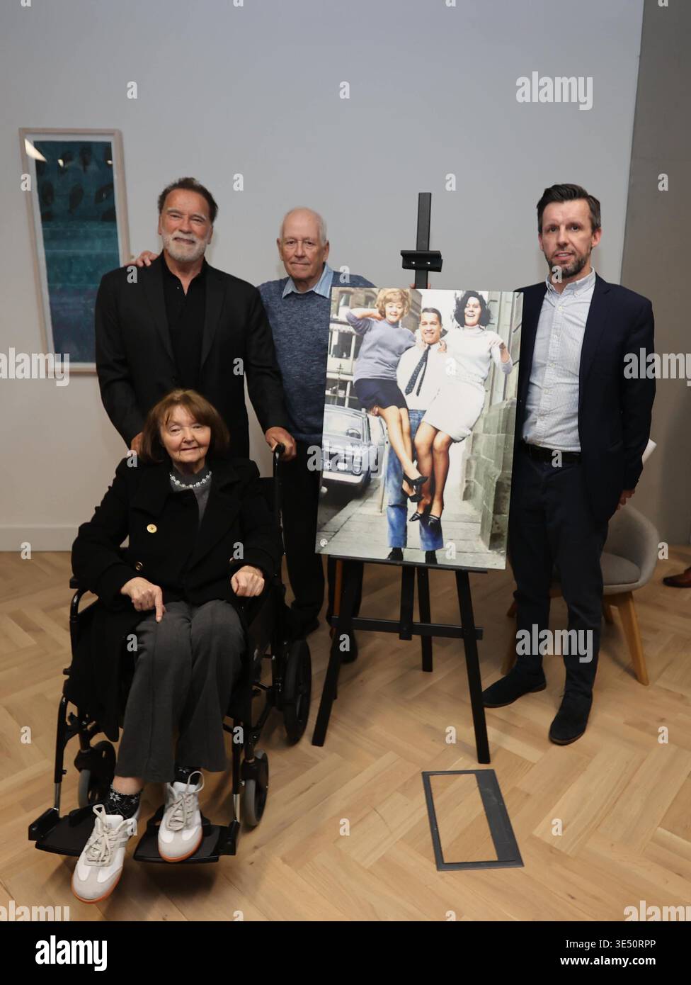 Arnold Schwarzenegger (left) poses for a picture next to a picture of ...