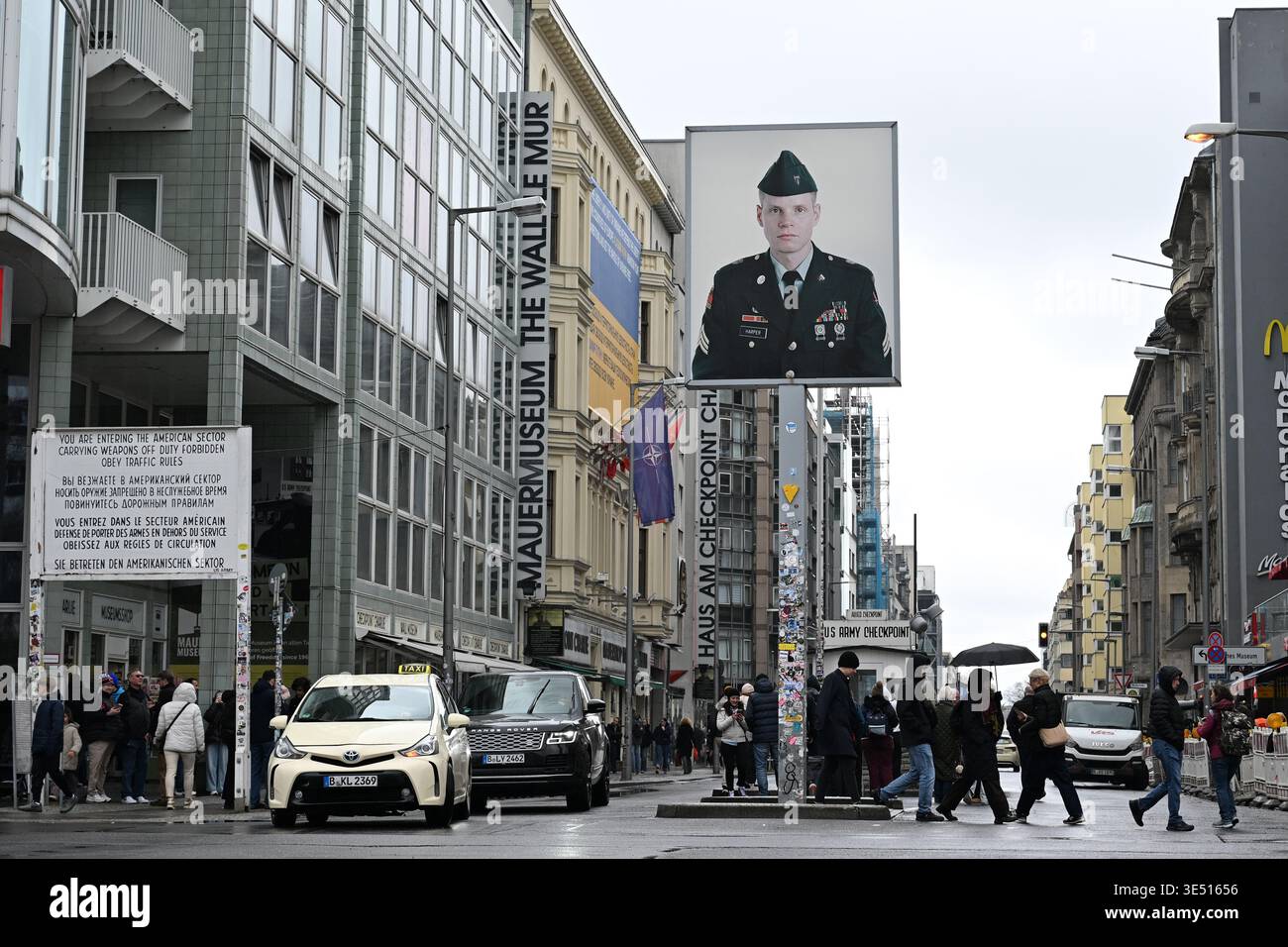 30 March 2026, Berlin: Tourists linger at "Checkpoint Charlie". A ...