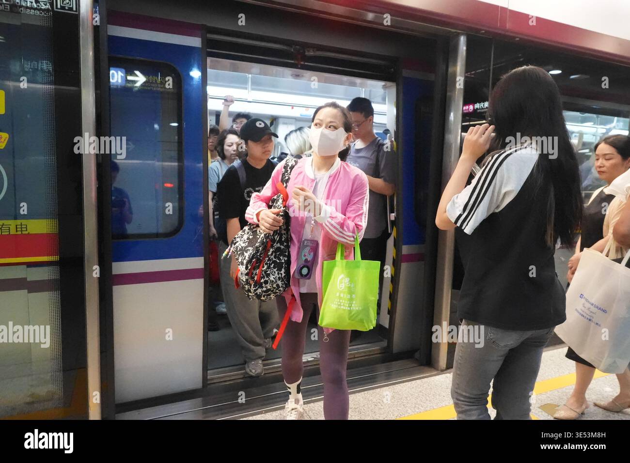 People exit from a subway train at Donghu station in Guangzhou Stock ...