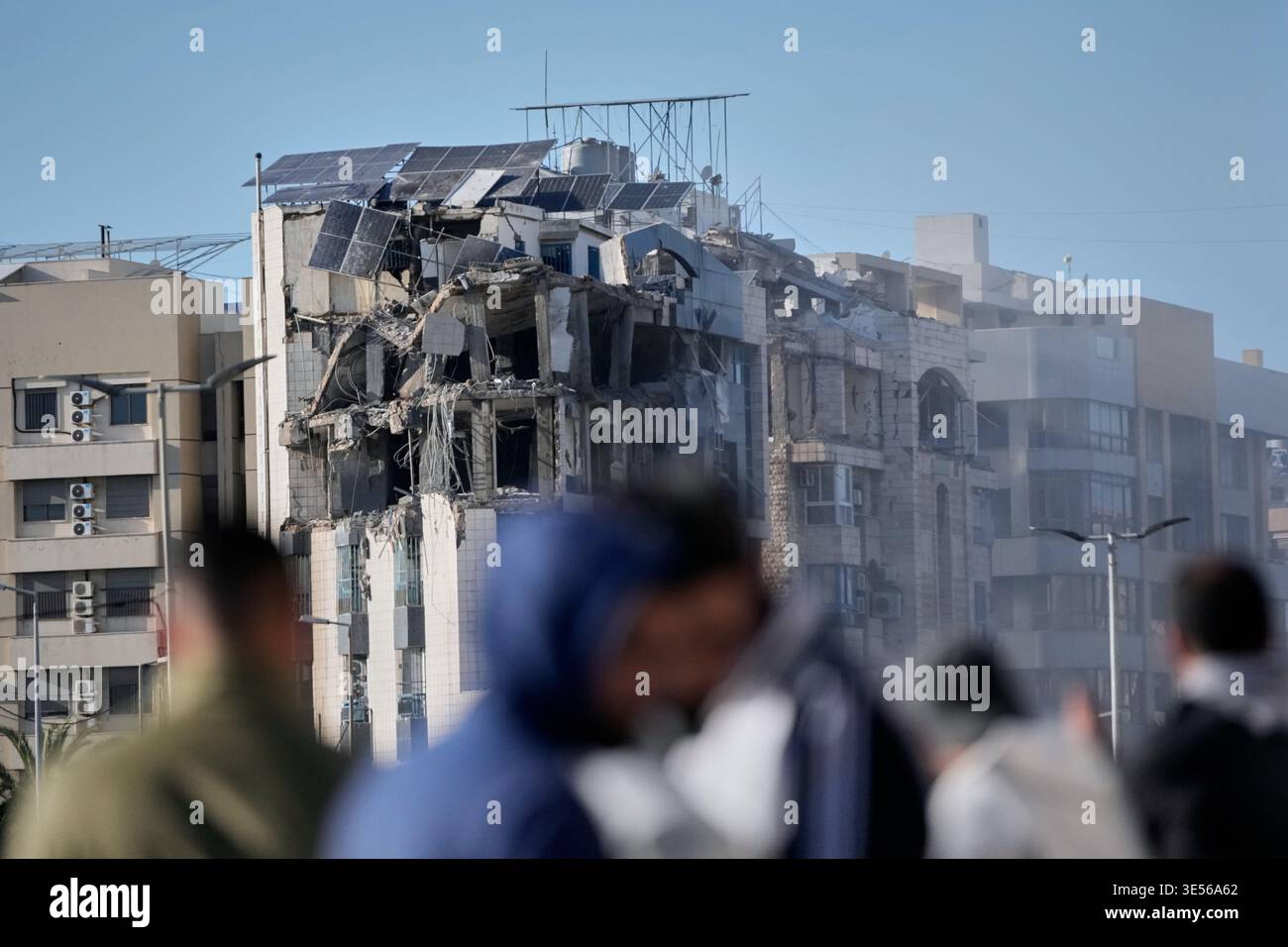 Bystanders look at a building after it was hit by an Israeli strike on ...