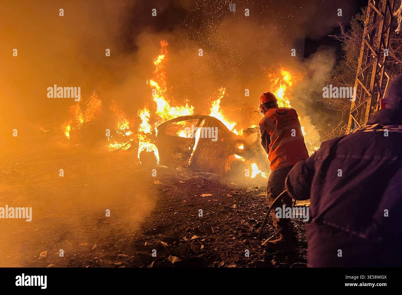 Rescue workers battle flames engulfing vehicles at the site of an ...