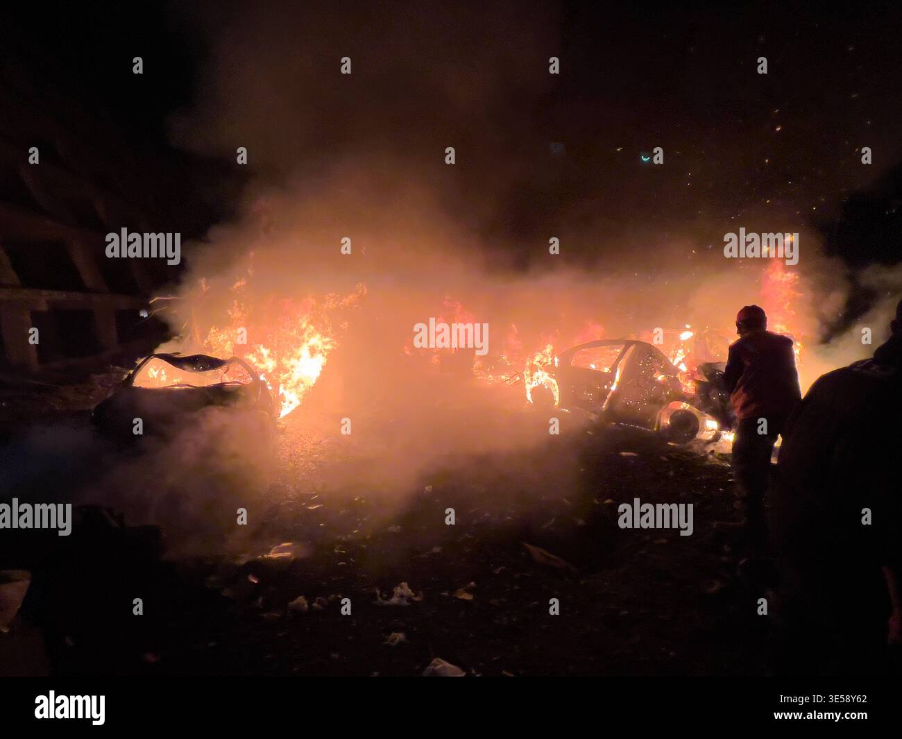A firefighter extinguishes a car at the site of Israeli airstrikes in ...