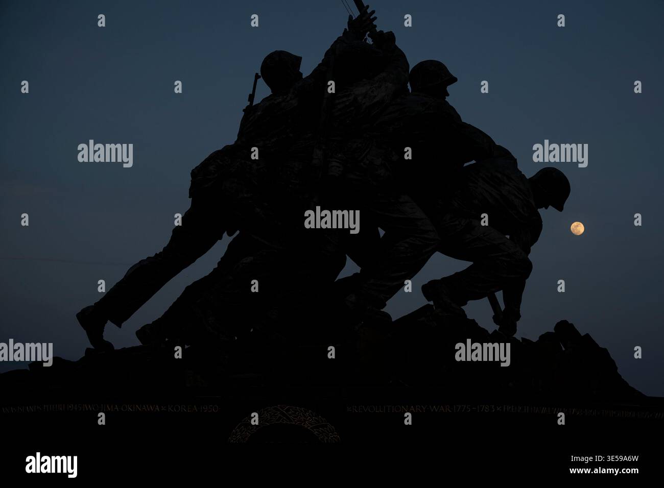 A full moon rises behind the U.S. Marine Corps War Memorial in ...