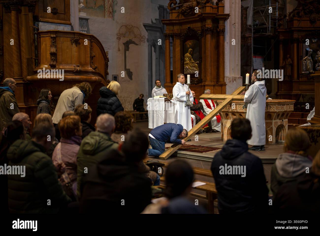 A worshiper kisses a cross during Good Friday Mass at St. Francis of ...