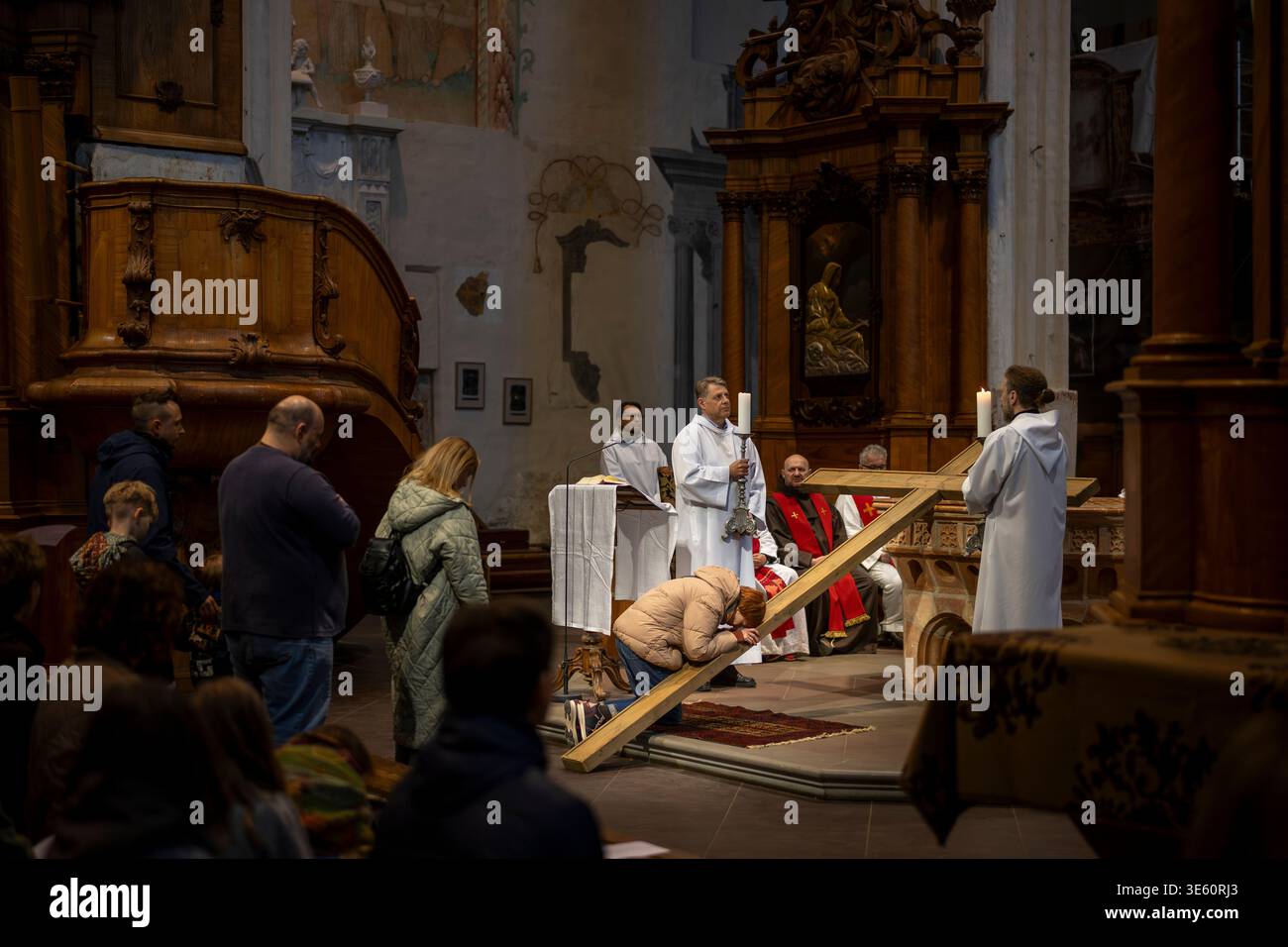 A worshiper kisses a cross during Good Friday Mass at St. Francis of ...