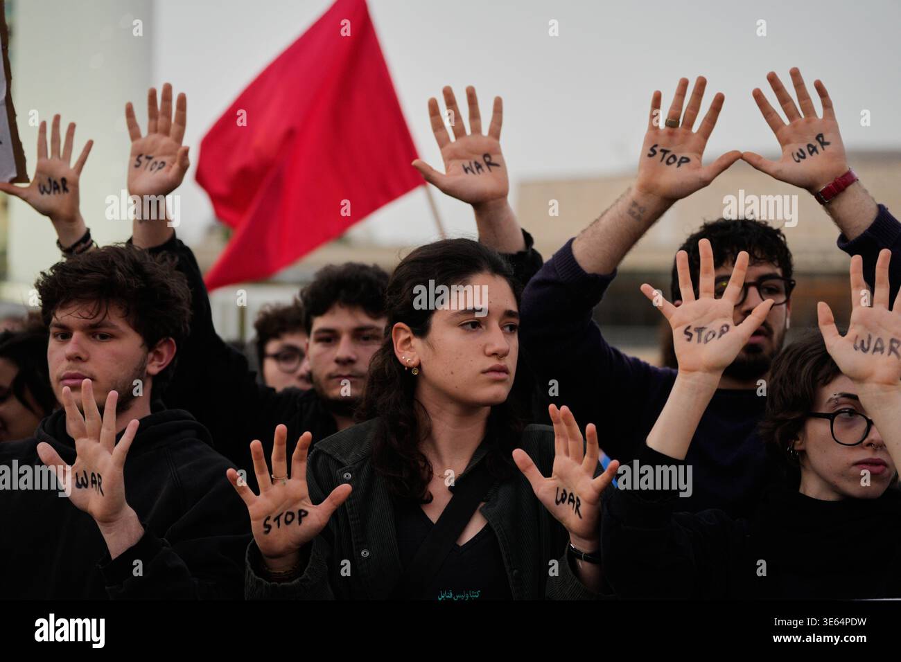 People raise their hands during a protest calling for an end to the war ...