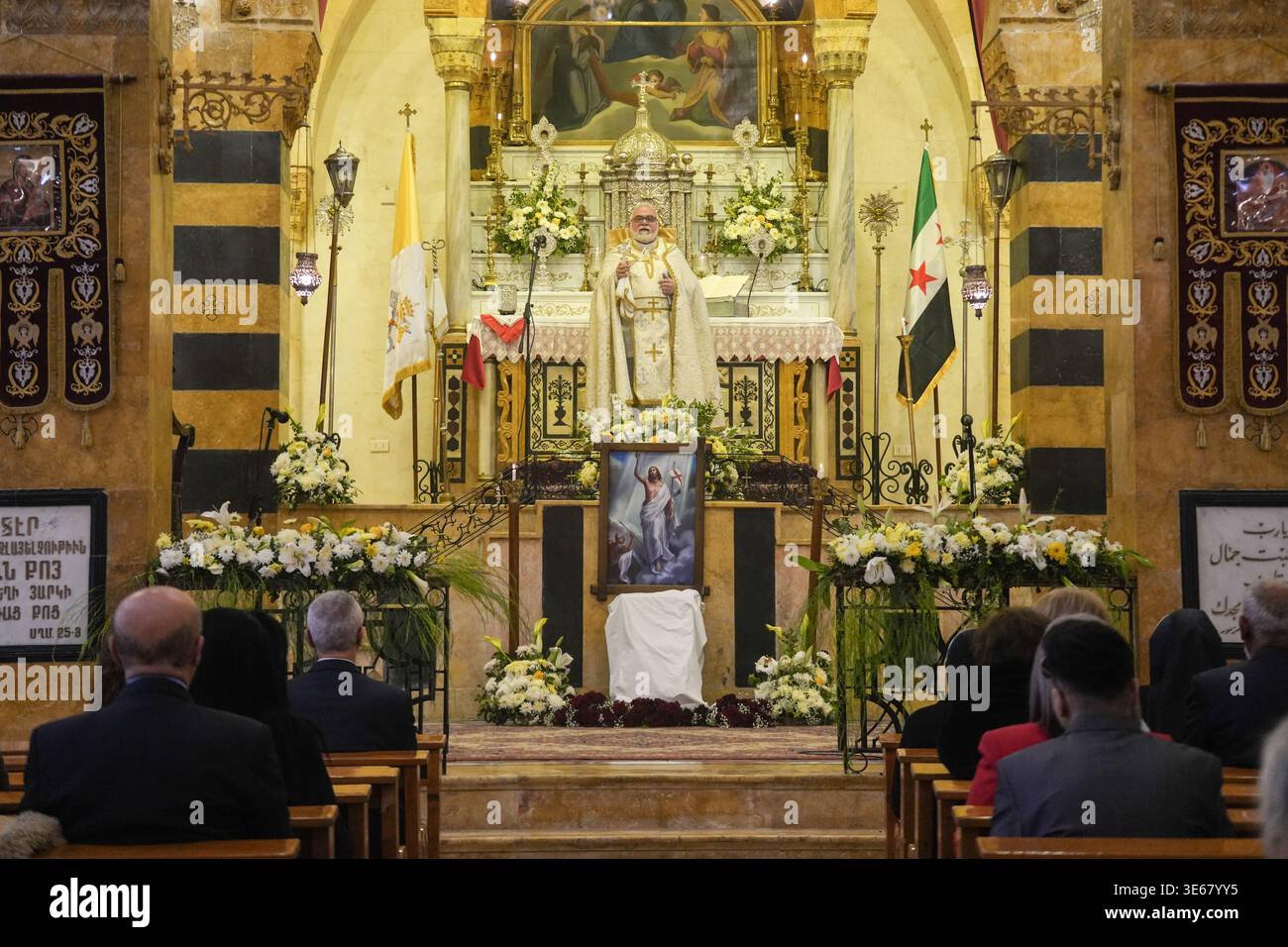 05 April 2026, Syria, Aleppo: A priest leads the Easter Sunday service ...