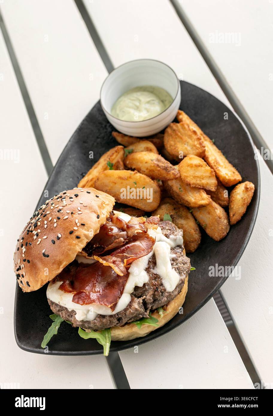 Gourmet wagyu beef burger wirh bacon, cheese and wedge fries on outdoor ...