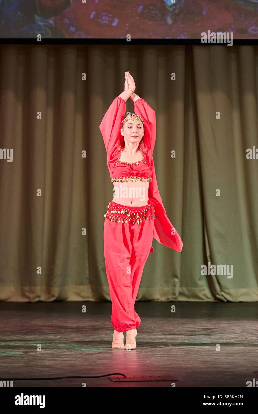 Graceful odalisque dancer wearing vibrant red traditional costume with ...