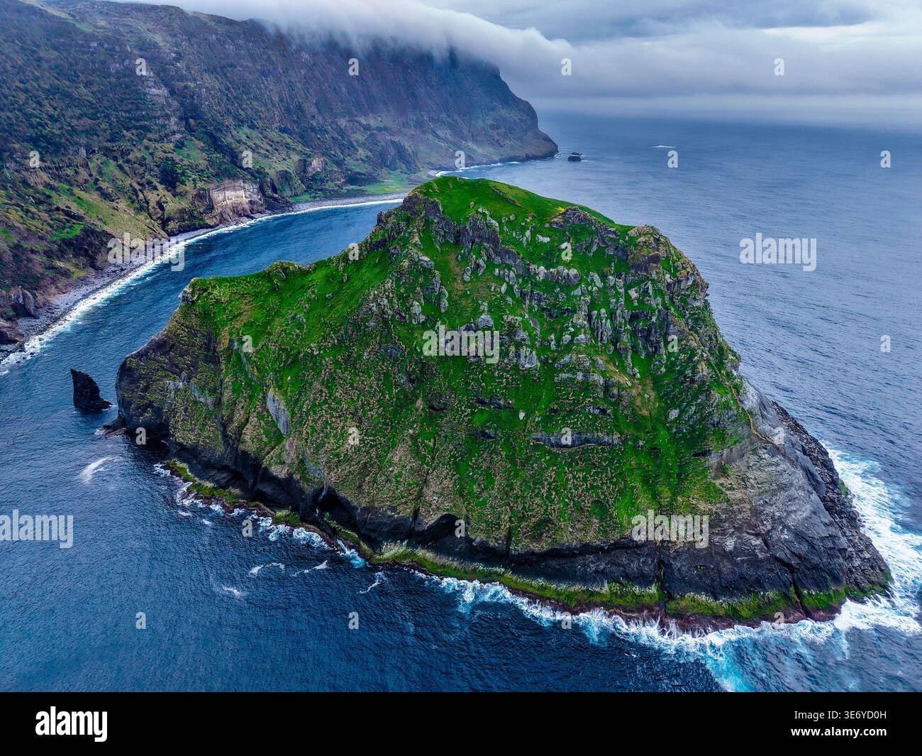 Aerial view of a verdant island, contrasting with the dark blue sea ...