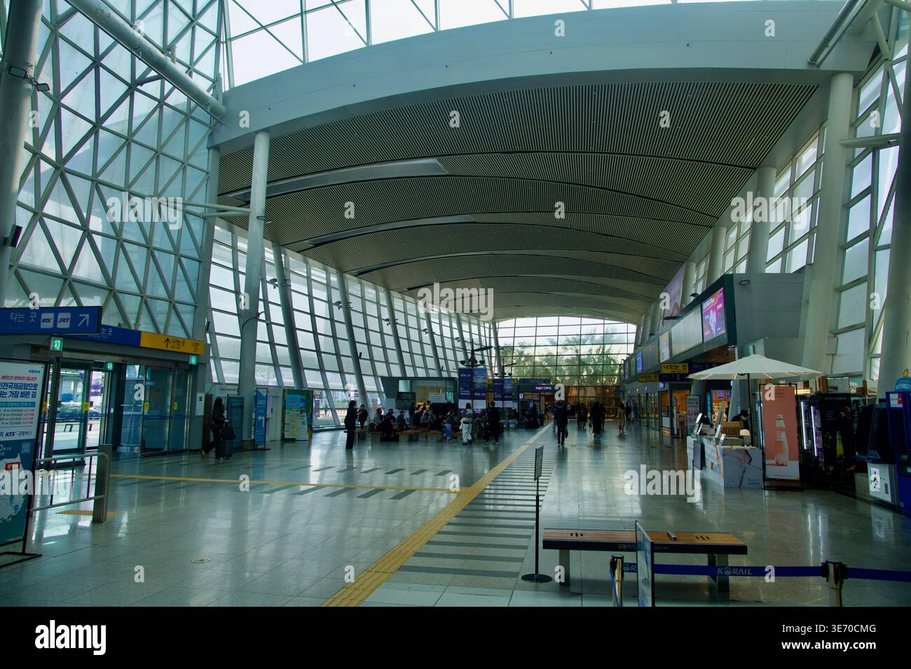 Inside Ulsan Station, the main hall opens beneath a curved ceiling with ...