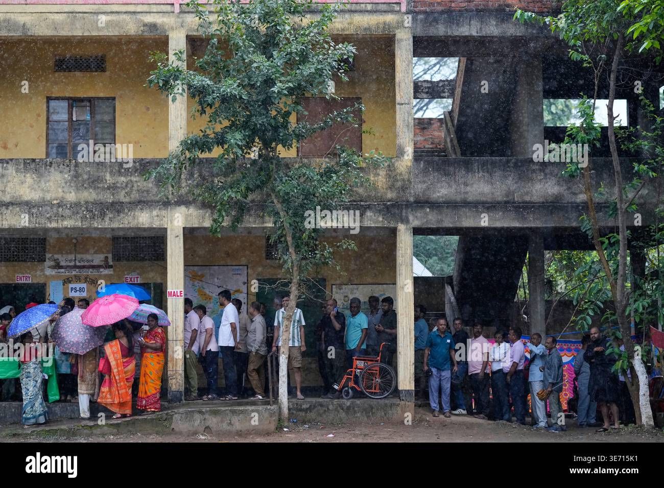 People stand in queue to cast their votes at a polling center during ...