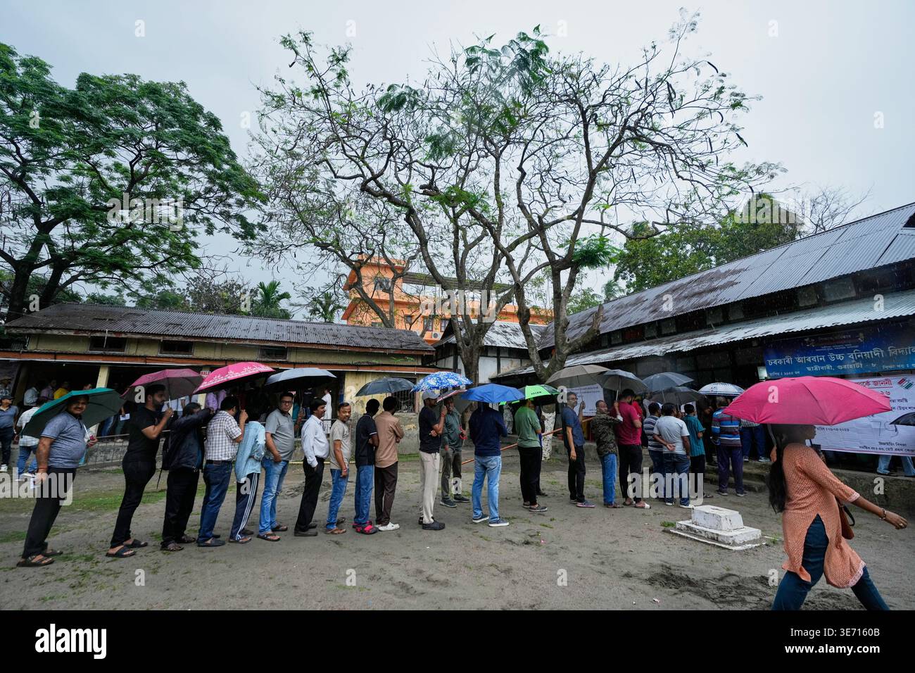 People stand in queue to cast their votes at a polling center during ...