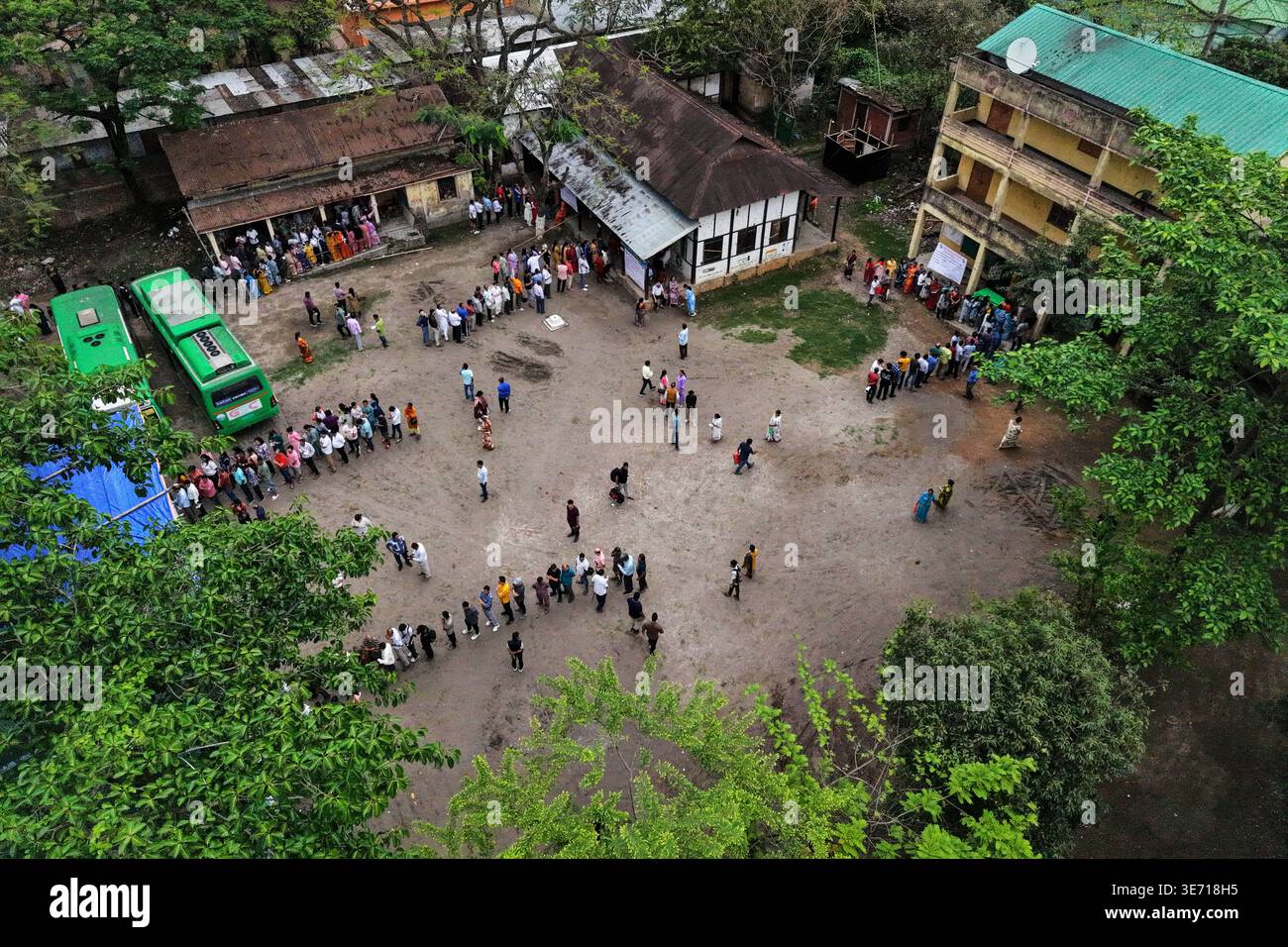 People stand in queue to cast their votes at a polling center during ...