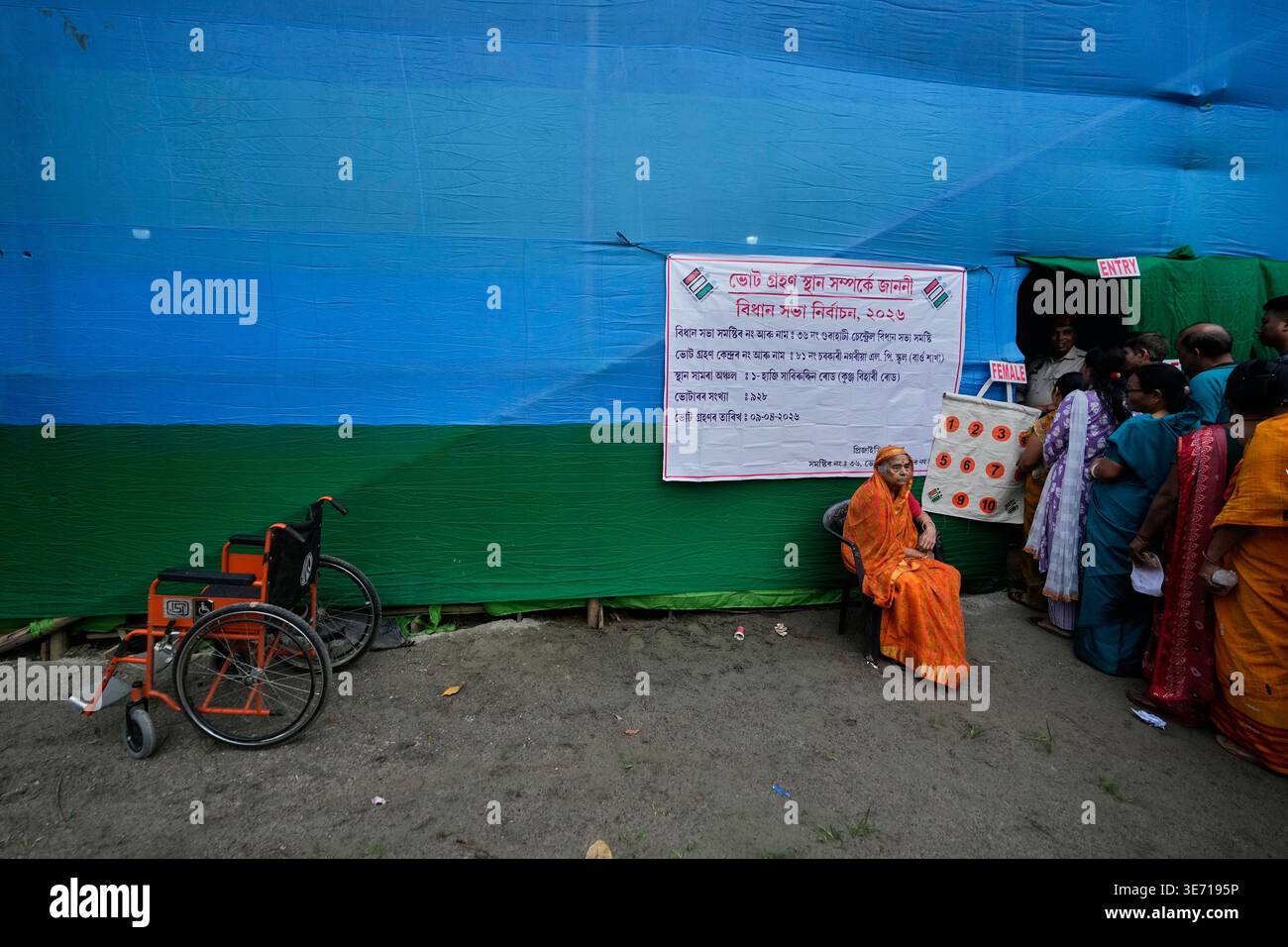 People stand in queue to cast their votes at a polling center during ...