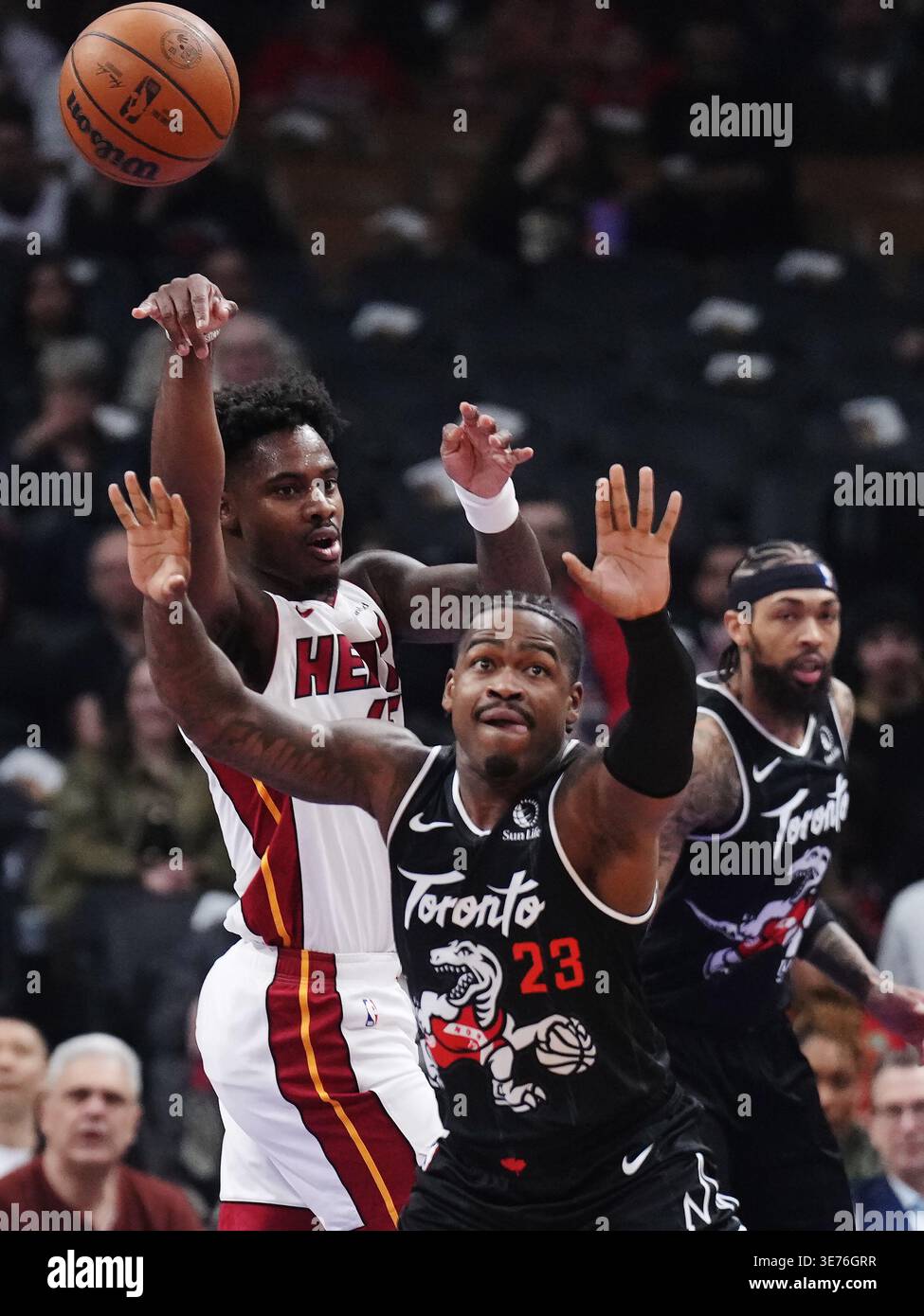 Miami Heat's Davion Mitchell (left) passes over Toronto Raptors' Jamal ...